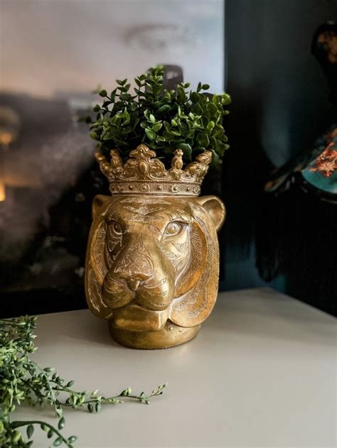 A Gold Lion Planter With A Crown On It S Head Sitting On A Table