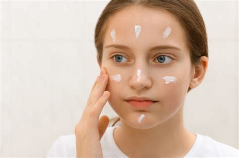 Gadis Menempatkan Krim Di Wajahnya Wajah Seorang Gadis Remaja Dengan Kulit Yang Baik Dia Melihat