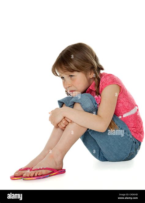 Preteen Girl Sitting On Beach With Barefeet Hugging Knees Stock