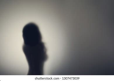 Silhouette Naked Womans Body Behind Glass Stock Photo