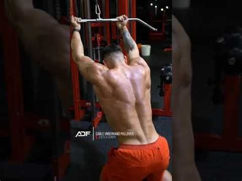 A Man Doing Pull Ups On A Bar In The Gym With No Shirt And Red Shorts
