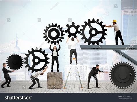 Teamwork Works Together To Build A Gear System Stock Photo 147480173