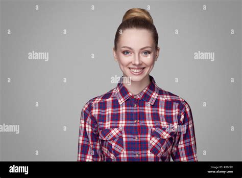 Portrait Of Satisfied Beautiful Blonde Girl In Pink Checkered Shirt Collected Bun Hairstyle And