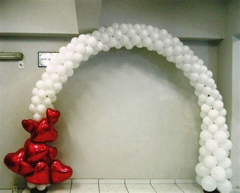 An Arch Made Out Of White Balloons And Red Hearts
