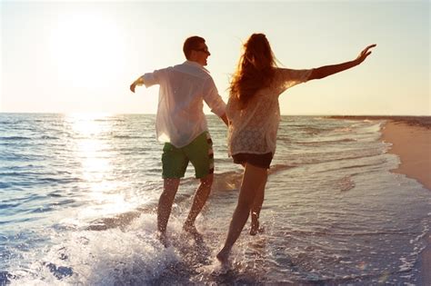Feliz Pareja Joven Disfrutando Del Mar Foto Premium