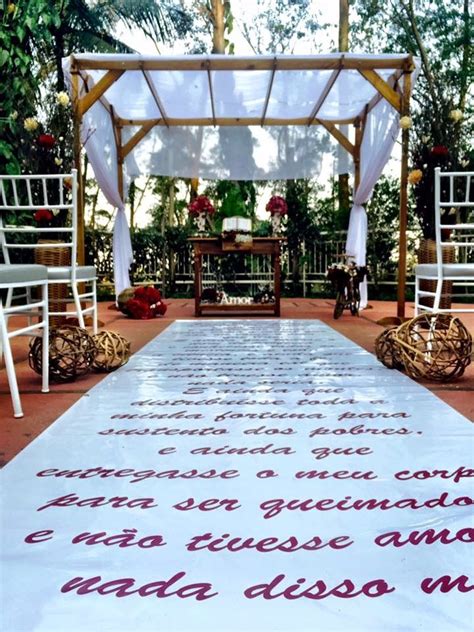 An Outdoor Ceremony With White Chairs And Flowers On The Aisle
