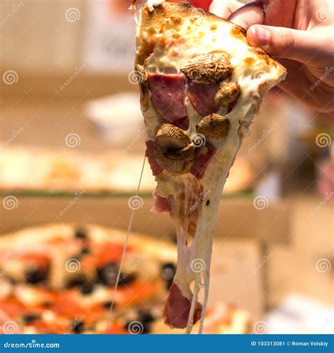 El Queso Estira De Un Pedazo De Pizza Con Las Setas En La Mano De Un
