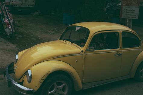 Underexposed Shot Of A Vintage Yellow Volkswagen Beetle Vintage
