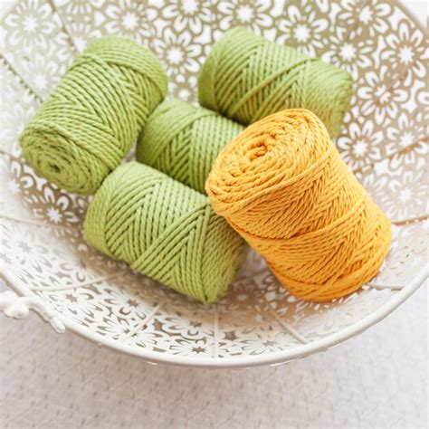 Trenzado de macramé hecho a mano e hilos de algodón sobre fondo textil