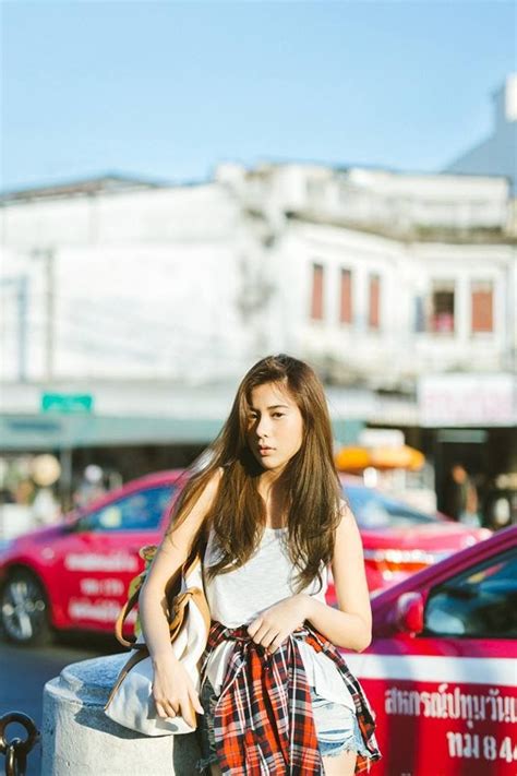 A Woman Sitting On Top Of A Cement Pillar