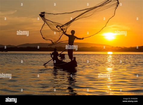 Silueta de pescadores lanzando su red de pesca fotografías e imágenes