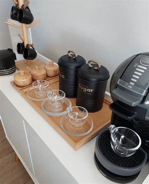 There Is A Coffee Maker And Cups On The Counter Next To Each Other With