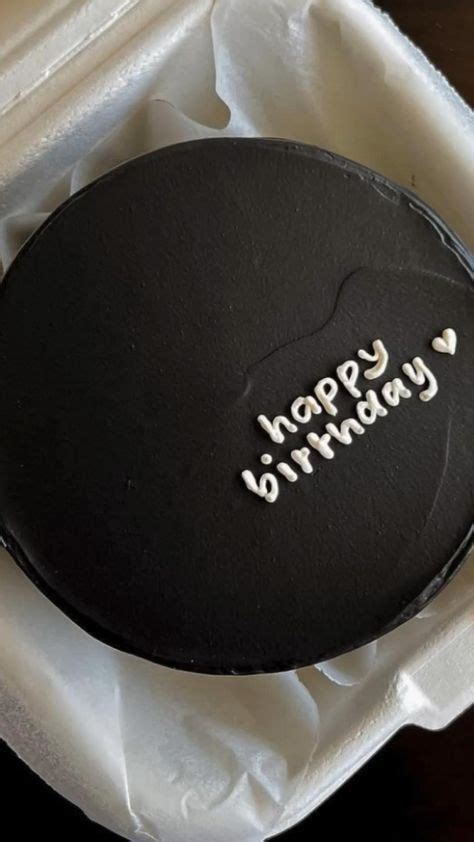 A Black Birthday Cake In A White Box With Writing On The Top And Happy