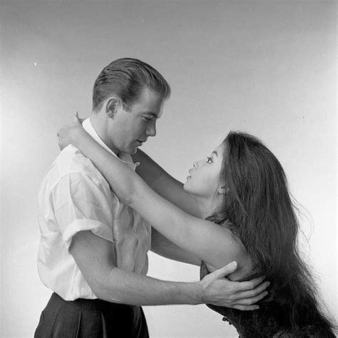 A Man And Woman Embracing Each Other In An Old Black And White Photo