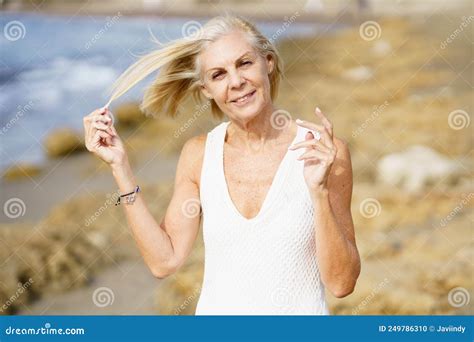 Smiling Mature Woman Walking On The Beach Elderly Female Standing At A