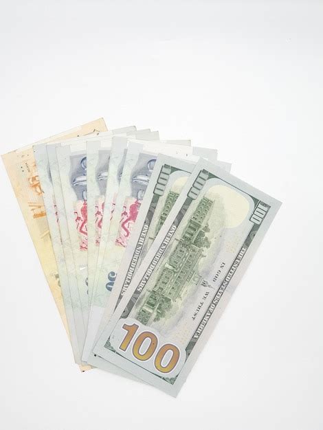 Una pila de billetes de 100 y 100 está sobre un fondo blanco Foto