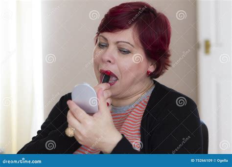 Donna Matura Con Lo Specchio Ed Il Rossetto Immagine Stock Immagine