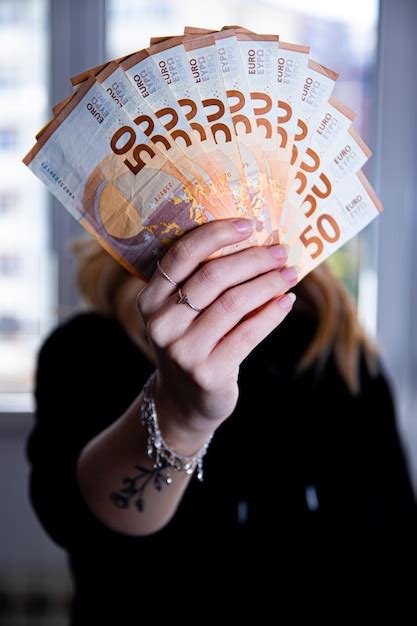 Una Mujer Sostiene Una Pila De Billetes De 50 Euros Foto Premium