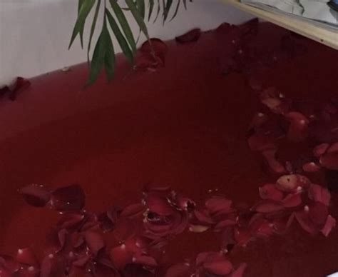 Red Liquid Flowing Down The Side Of A Bathtub Filled With Flowers And