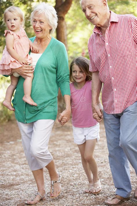 Grands Parents Sur La Promenade De Pays Avec Des Petits Enfants Image
