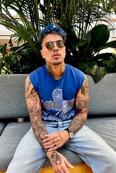 Tattooed Man Dancing On A Gray Couch
