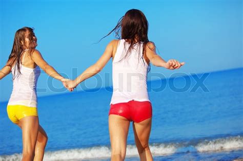 Smukke piger have det sjovt på stranden Stock foto Colourbox
