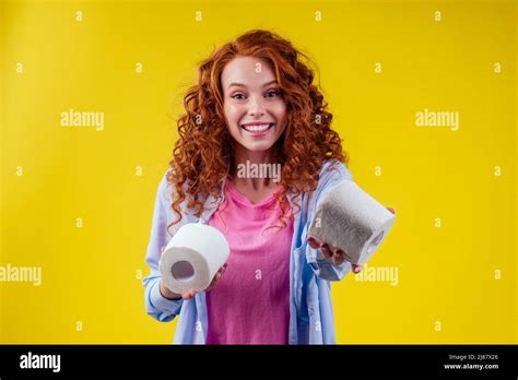 Beautiful Curly Redhead Ginger Woman Choosing Eco Toilet Paper Roll On Yellow Color Background