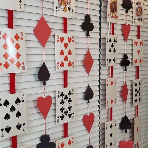 Several Playing Cards Are Hanging On The Wall With Red And Black Hearts
