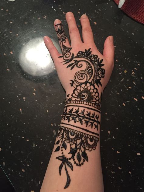 A Woman S Hand With Henna Tattoos On It