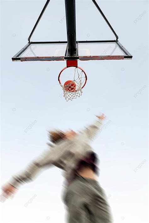 A Male Shooting A Basketball Into The Hoop On A Court For Basketball