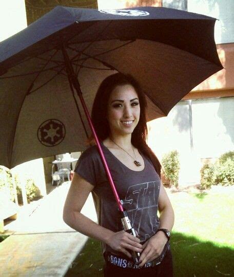 A Woman Standing Under An Umbrella In The Sun