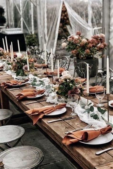 A Long Wooden Table Topped With Lots Of Plates And Place Settings