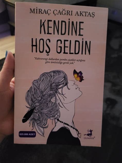 A Person Holding Up A Book In Their Hand