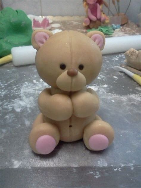 A Small Teddy Bear Sitting On Top Of A Table