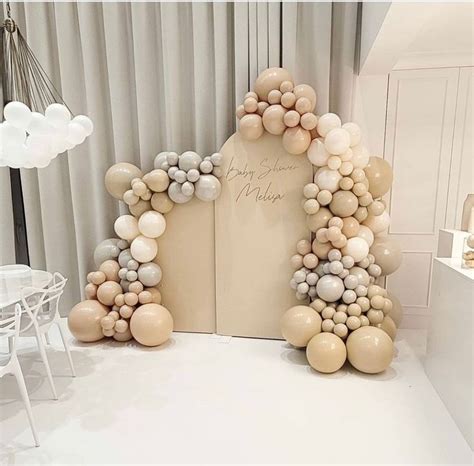 An Arch Made Out Of Balloons Is On Display In A Room With White Walls