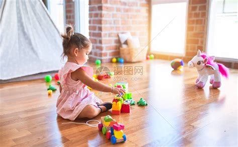 坐在地板上与小汽车玩具耍的年轻漂亮的幼儿高清图片下载 正版图片506324558 摄图网