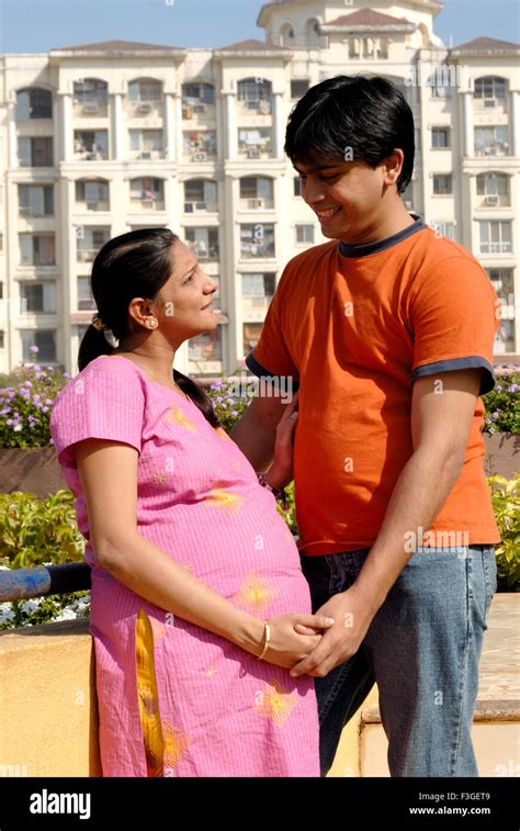 South Asian Indian Husband With Pregnant Wife Standing Looking Each