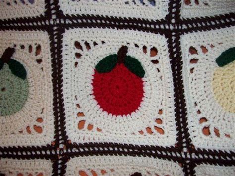 A Crocheted Blanket With Apples And Leaves On It S Sides Is Shown