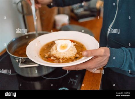 Traditional Polish Sour Soup Zurek In Ceramic Bowl Man Pouring Soup