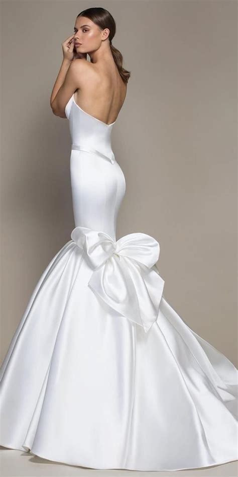 A Woman In A White Wedding Dress With A Big Bow On The Waist And Back