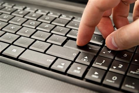 Close De Um Dedo Pressionando O Teclado Do Laptop Foto Premium