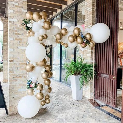 A Balloon Arch With Gold And White Balloons