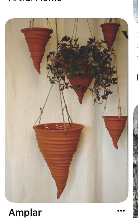 Three Hanging Clay Pots With Plants In Them