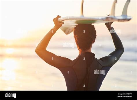 Shes Hitting The Water Running Rearview Shot Of A Female Surfer Carrying Her Surfboard Over Her