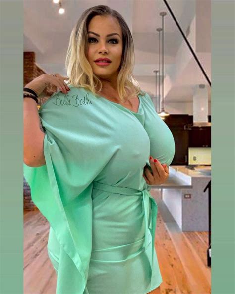 A Woman Posing In A Green Dress With Her Arms On Her Hips And One Hand On Her Hip