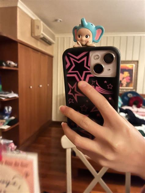 Someone Is Holding Up Their Cell Phone Case In The Room With Other
