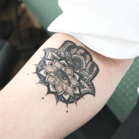 A Woman S Arm With A Tattoo On It That Has A Flower In The Center