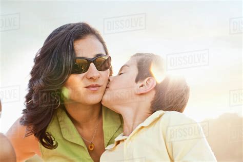 Son Kissing Mother On Cheek Outdoors Stock Photo Dissolve