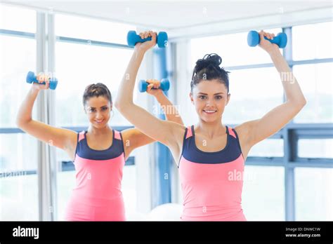 Two Fit Women Lifting Dumbbell Weights In Gym Stock Photo Alamy