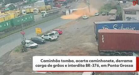 VÍDEO Caminhão tomba acerta caminhonete derrama carga de grãos e